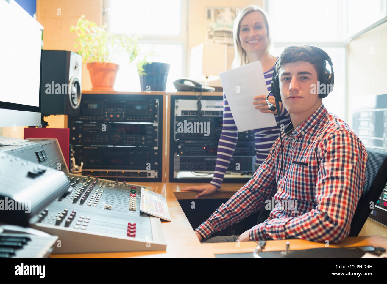 Portrait of male radio host with female employee Stock Photo - Alamy