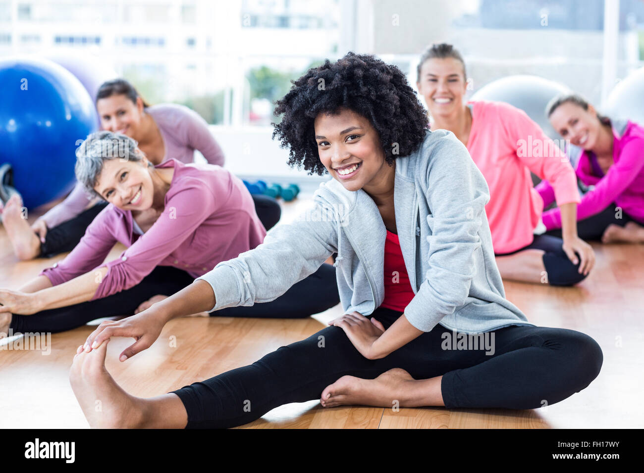 Cheerful fit women touching toes Stock Photo - Alamy