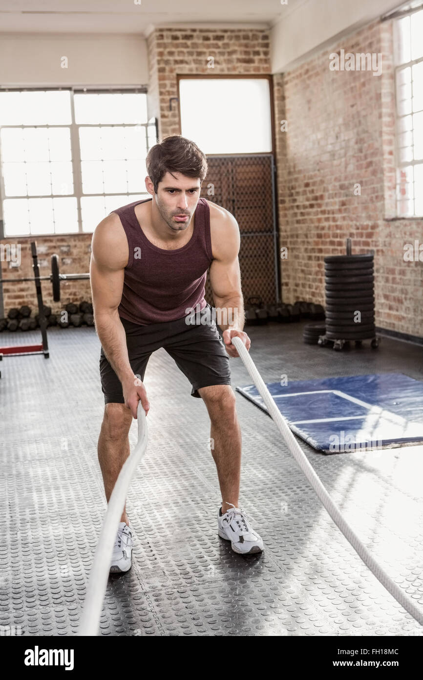 Man doing battling rope exercise Stock Photo - Alamy