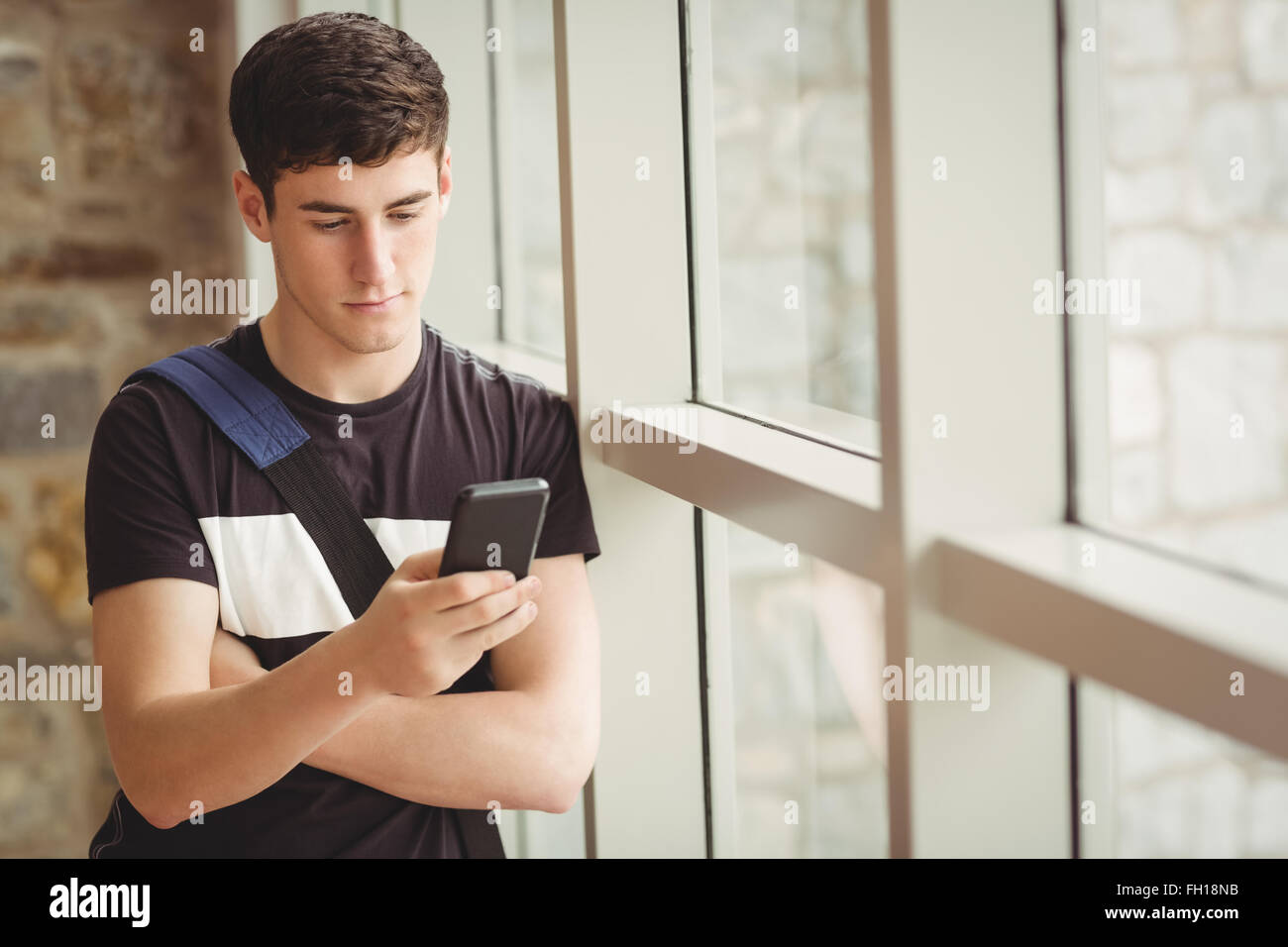 Male student using mobile phone in college Stock Photo - Alamy