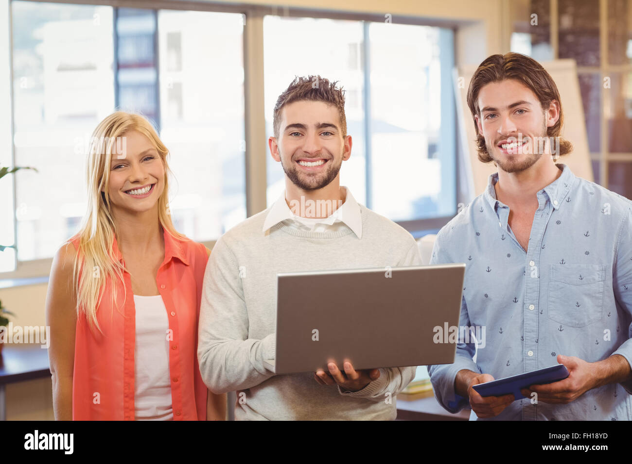 Happy business people using laptop Stock Photo - Alamy