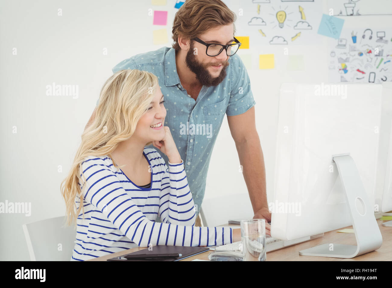 Smiling business people looking at computer Stock Photo - Alamy