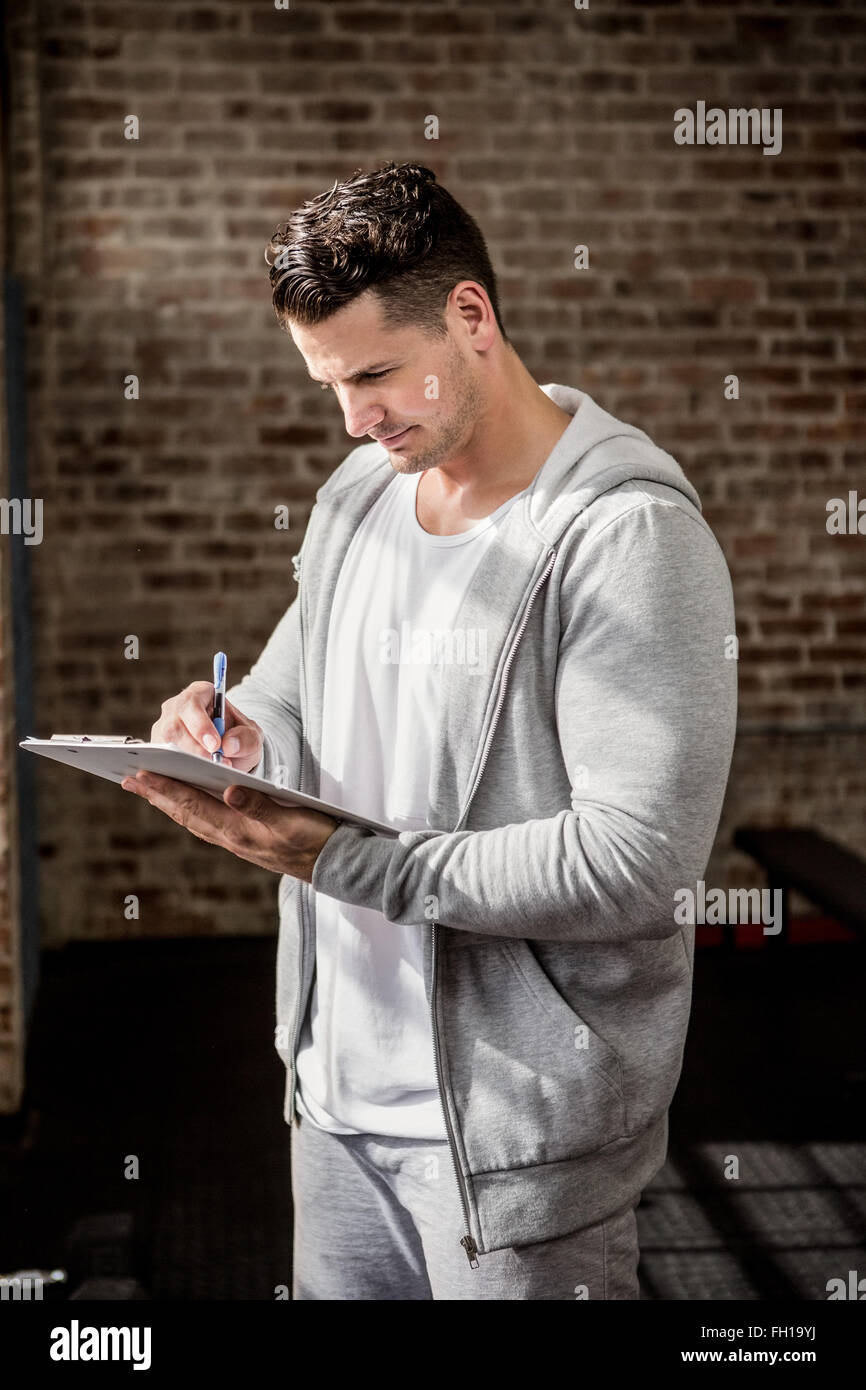 Muscular man writing on clipboard Stock Photo - Alamy