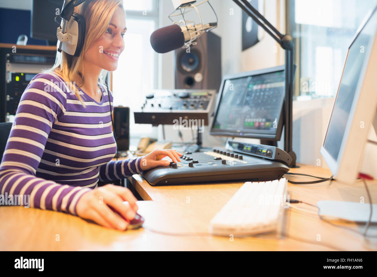 Female radio host using computer while broadcasting Stock Photo - Alamy