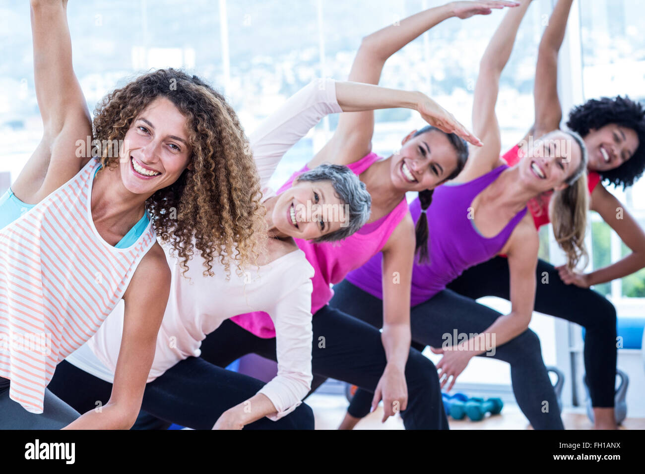 Portrait of smiling women bending with arms raised Stock Photo - Alamy