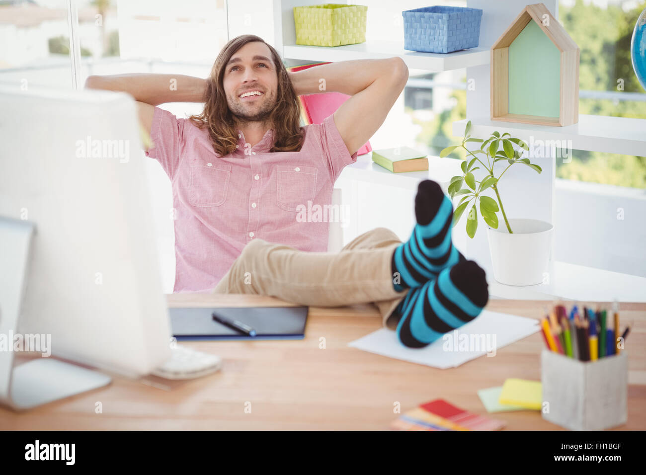 Hipster relaxing with legs on desk Stock Photo - Alamy