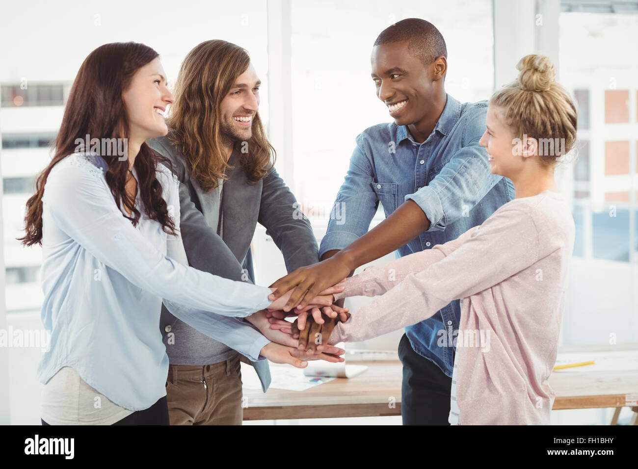 Smiling business team putting their hands together Stock Photo - Alamy