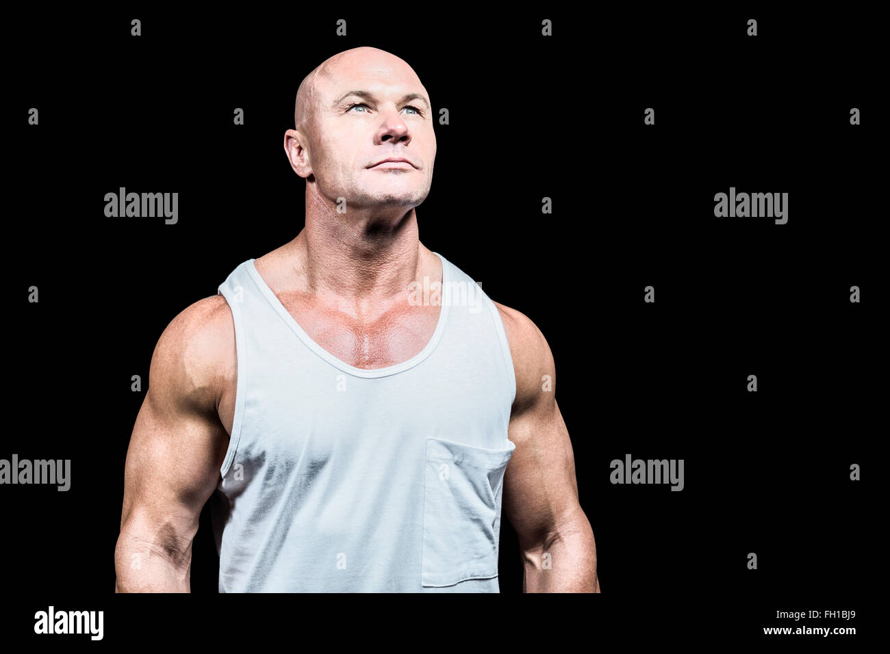 Bodybuilder in vest looking up Stock Photo - Alamy