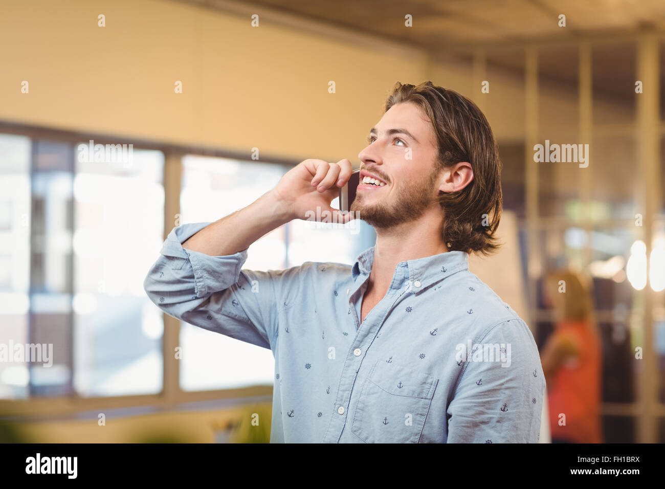 Businessman looking up while talking on phone Stock Photo - Alamy