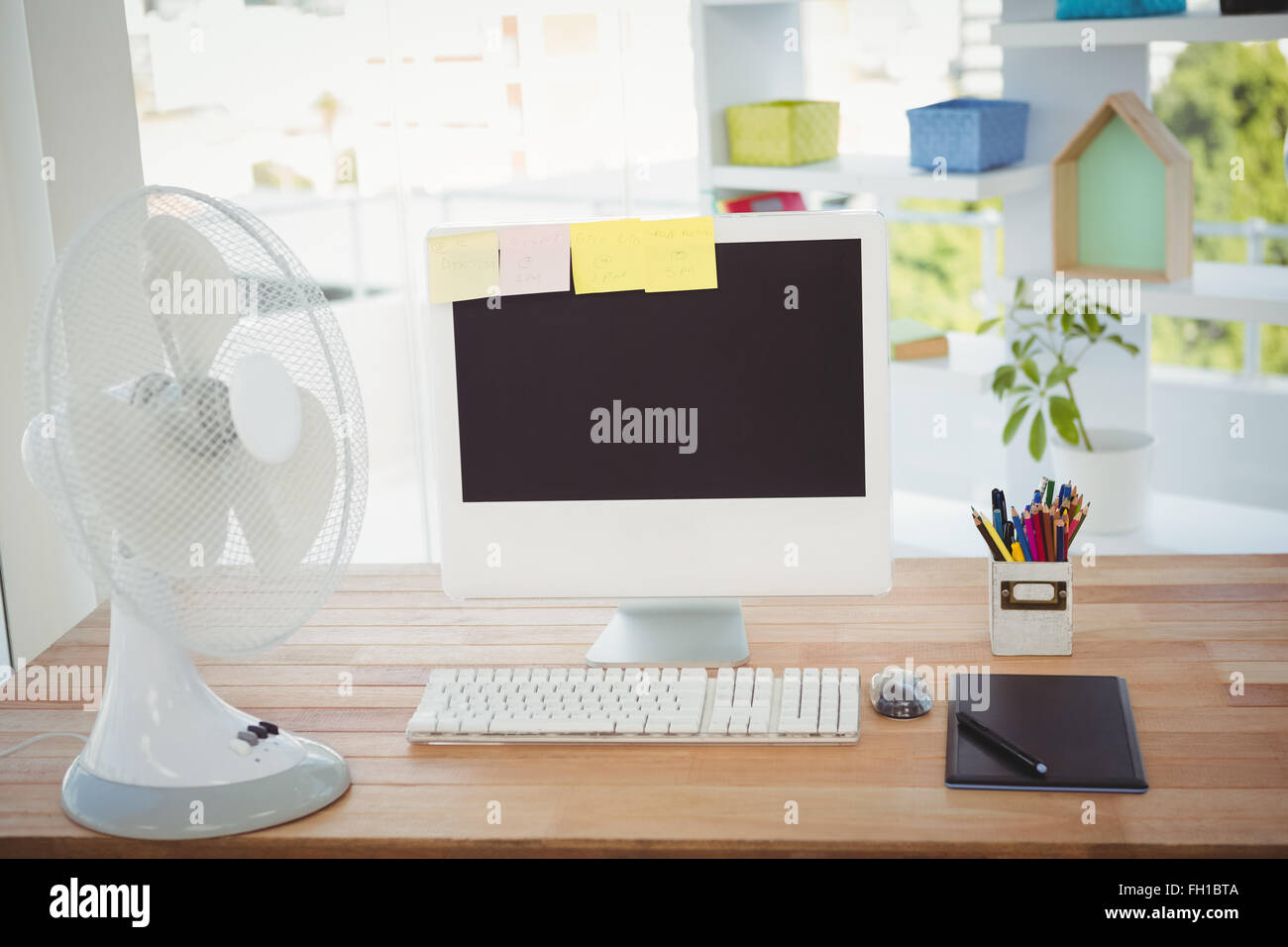 Sticky notes on computer monitor by electric fan Stock Photo - Alamy