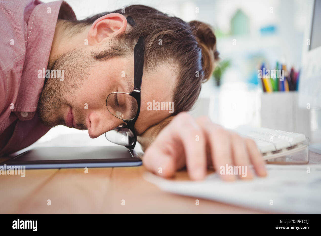 Businessman resting with head on desk Stock Photo - Alamy