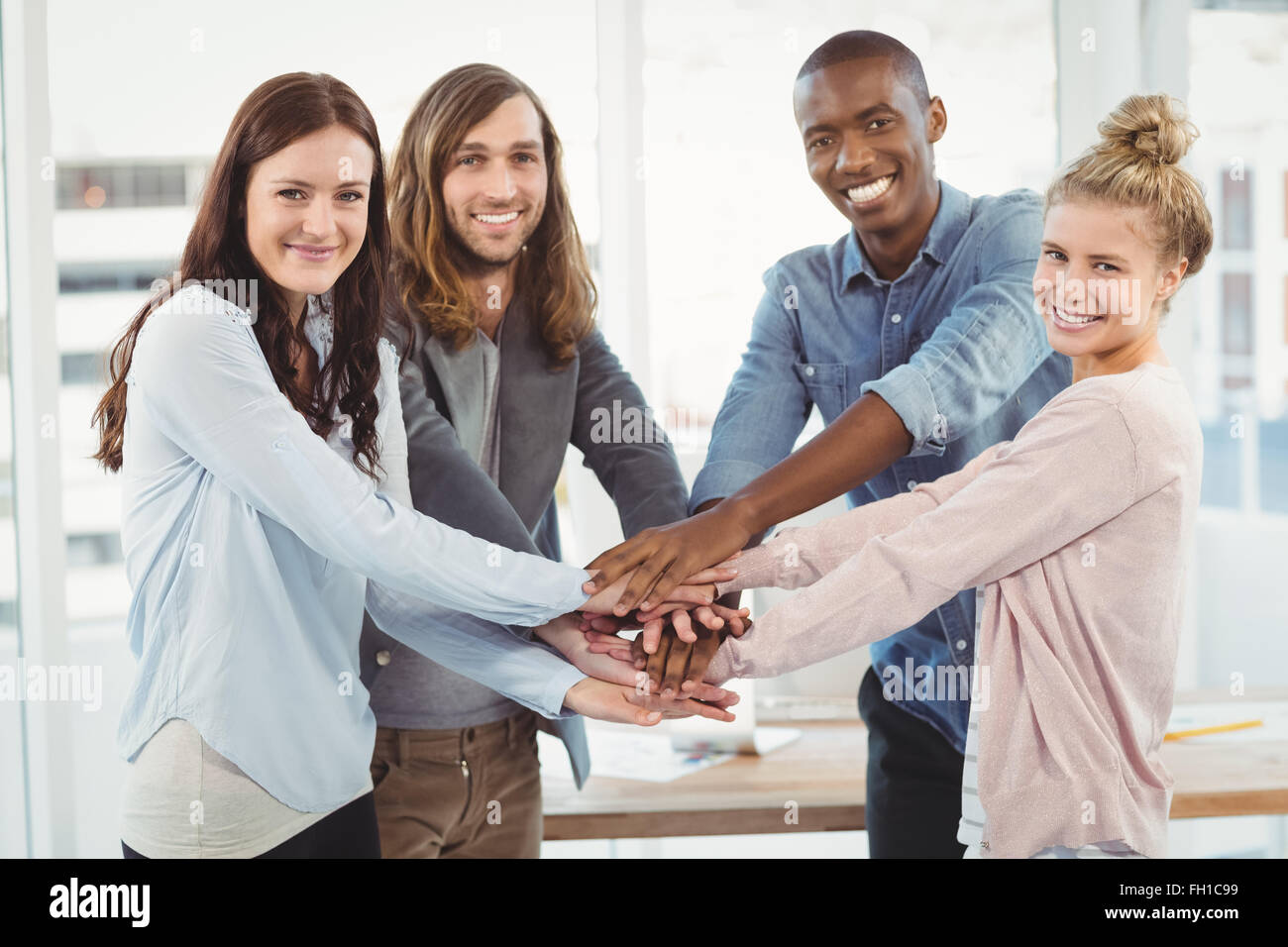 Portrait of smiling business team putting their hands together Stock ...