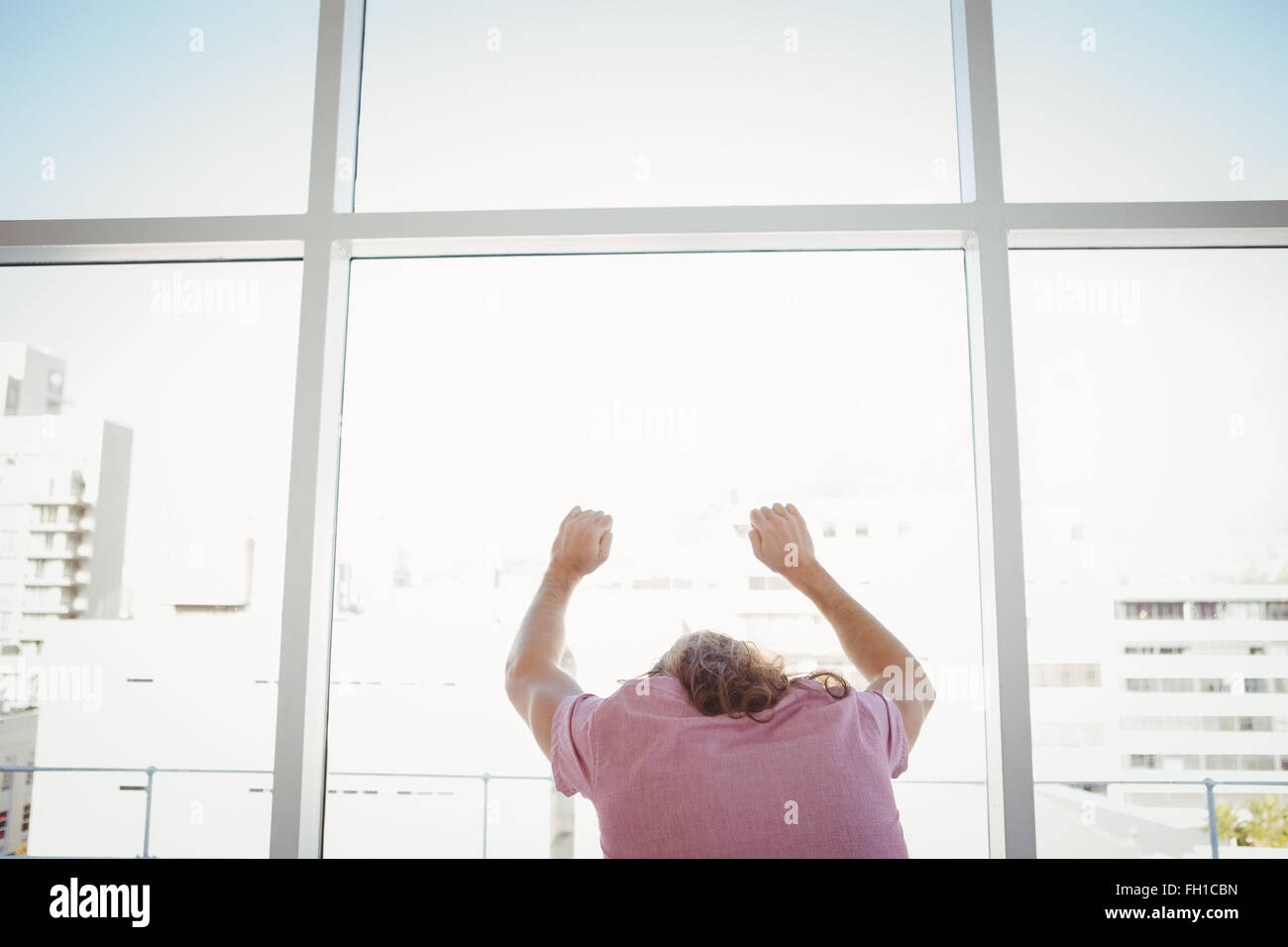 Rear view of hipster leaning against window glass Stock Photo - Alamy