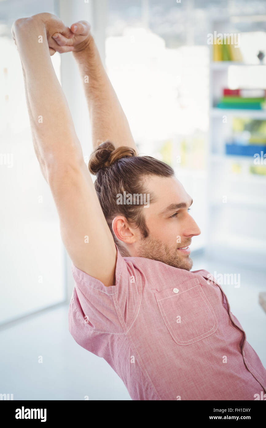 Businessman stretching in office Stock Photo - Alamy