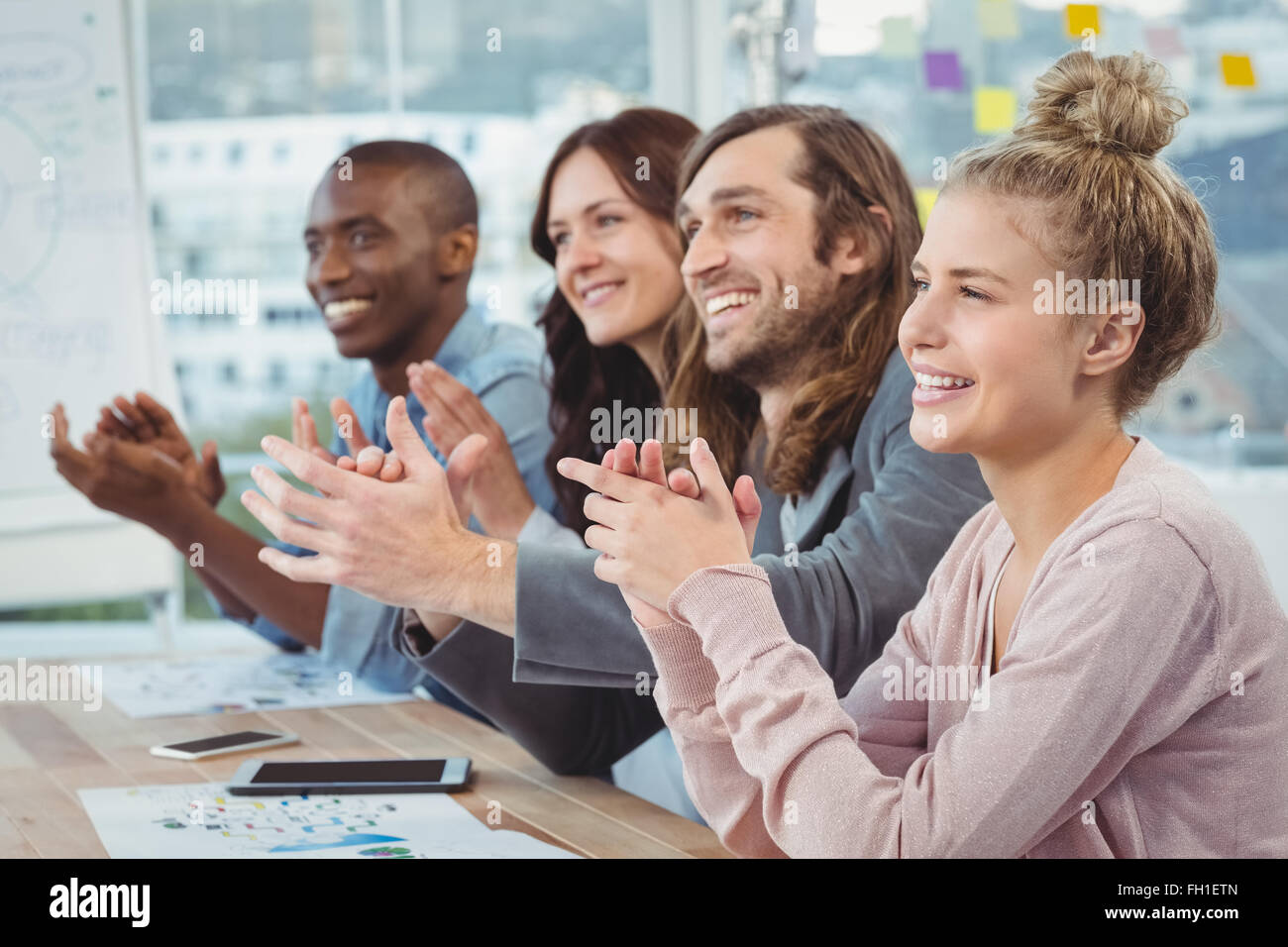 Happy business people clapping at desk Stock Photo - Alamy