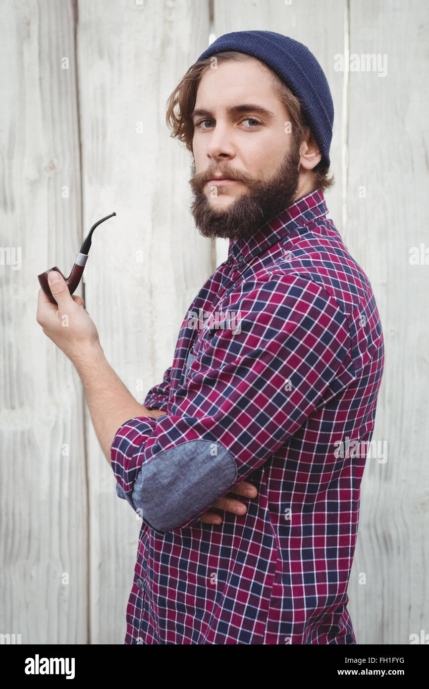 Side view of hipster holding smoking pipe Stock Photo - Alamy