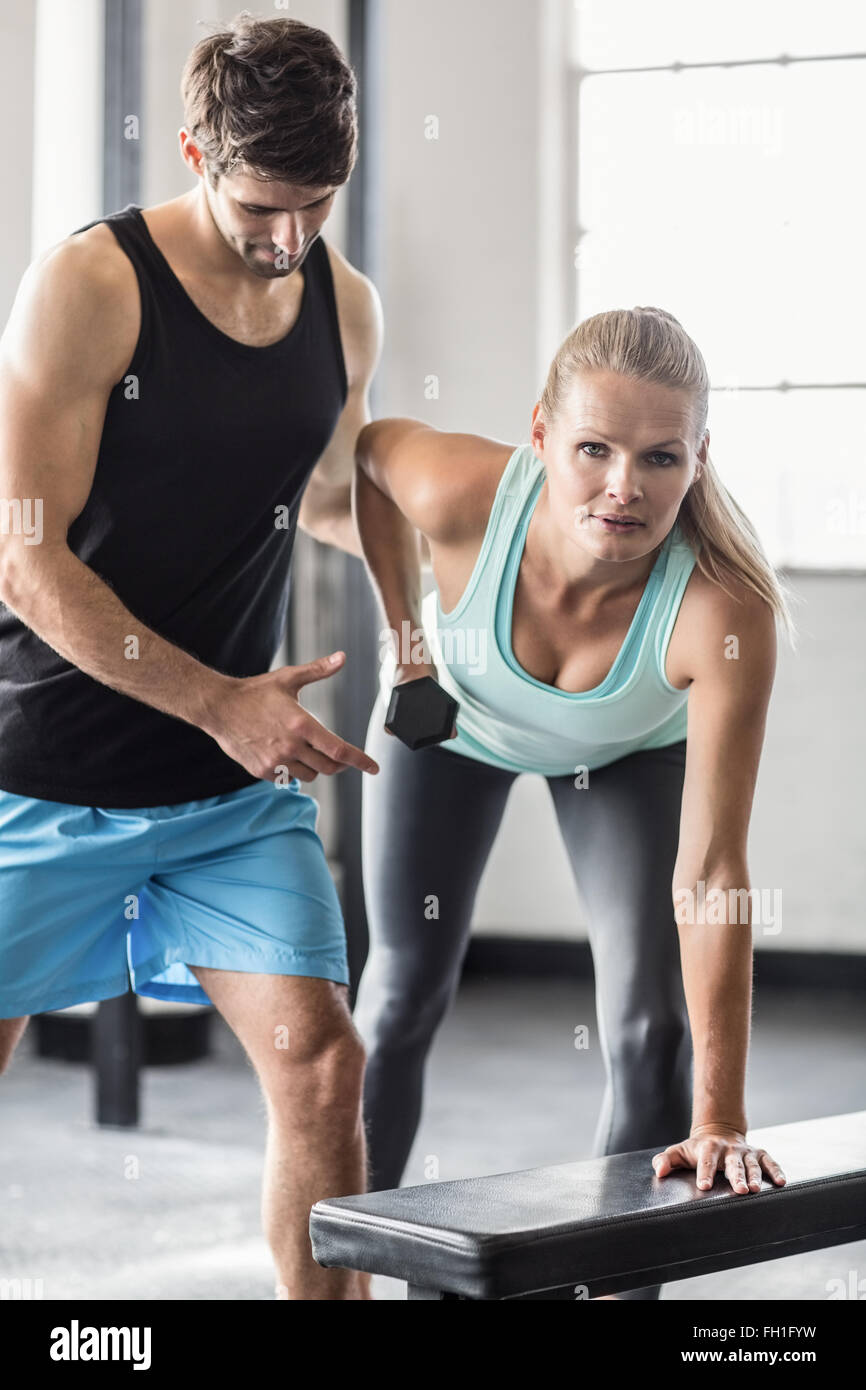 Sporty woman using dumbbells with personal trainor Stock Photo - Alamy