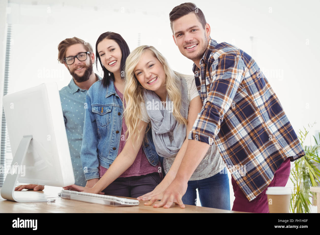 Portrait of smiling business people working at computer desk Stock ...