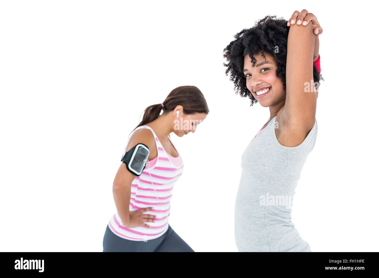 Woman stretching while female friend exercising Stock Photo - Alamy