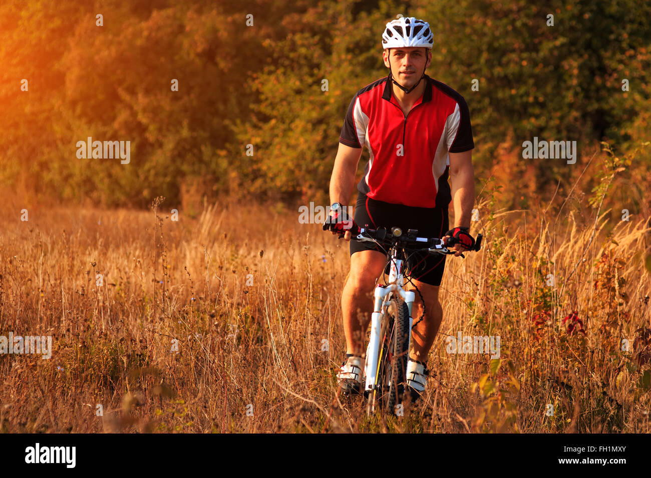 Man is riding a mountain bike in the field Stock Photo - Alamy