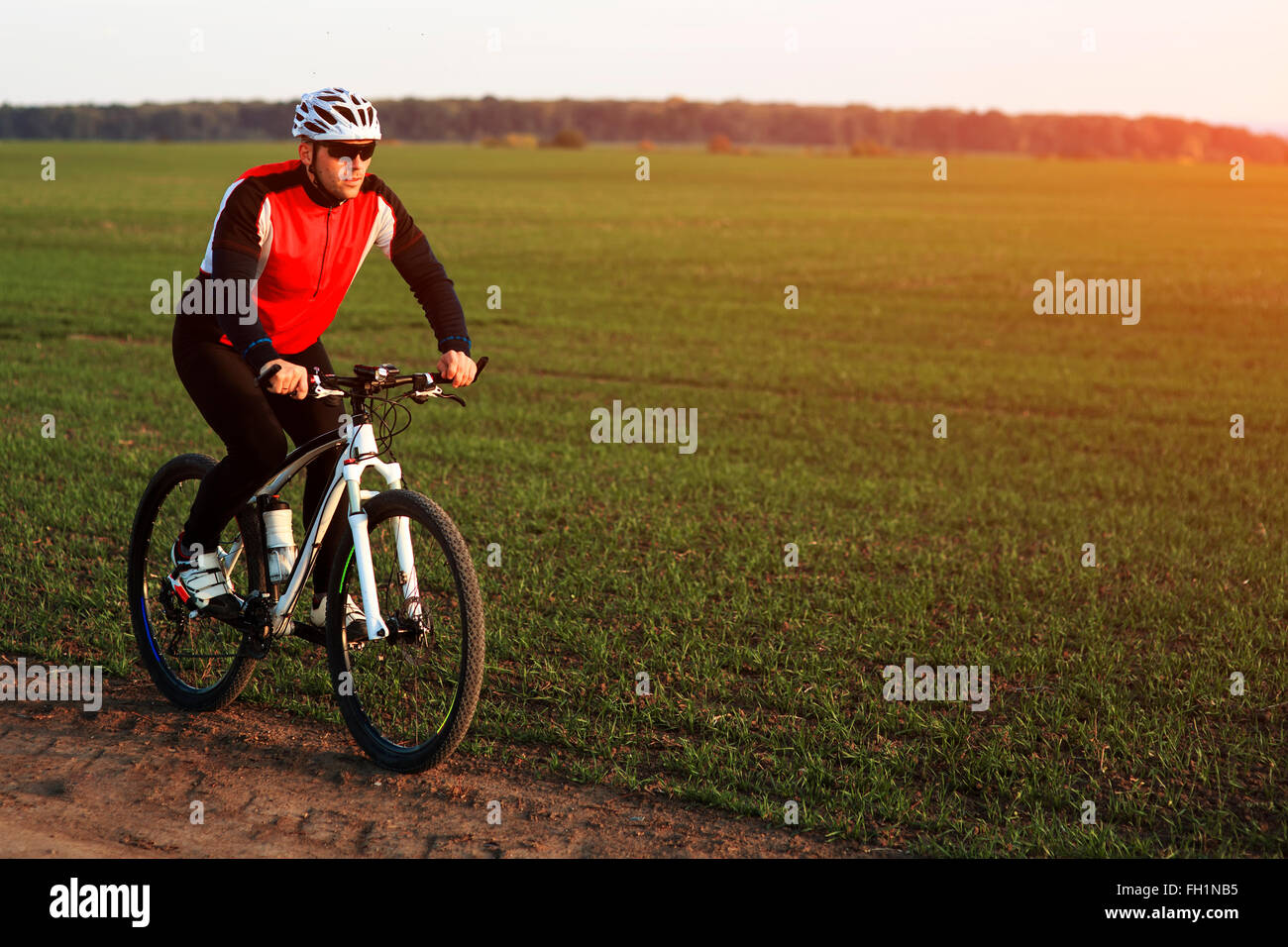 Man is riding a mountain bike in the field Stock Photo - Alamy