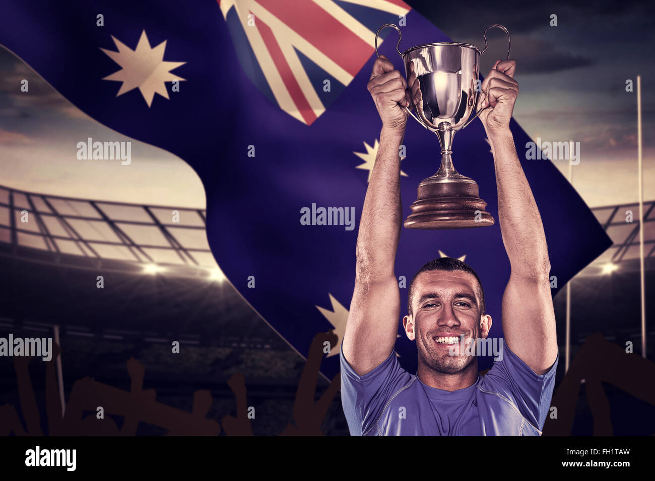 Composite image of portrait of smiling rugby player holding trophy ...