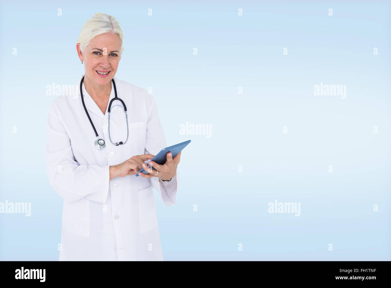 Composite image of smiling female doctor using table computer Stock ...