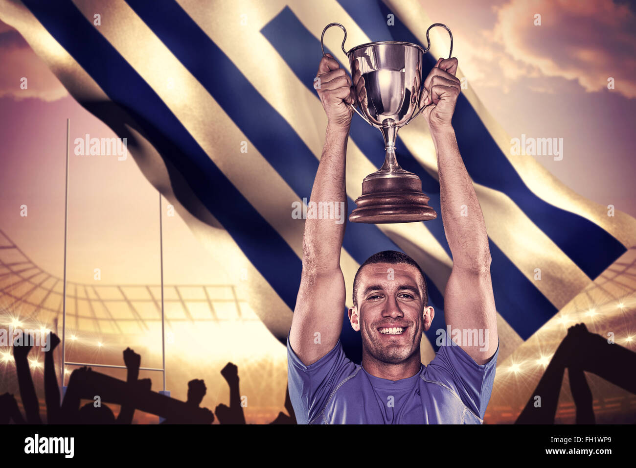 Composite image of portrait of smiling rugby player holding trophy ...
