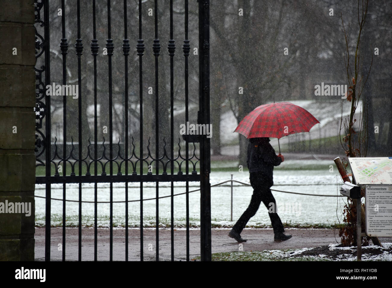 Fulda, Germany. 23rd Feb, 2016. A man walks through the slightly snow ...