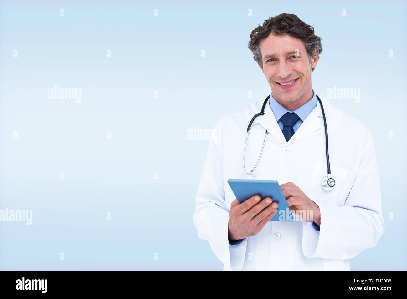 Composite image of portrait of smiling male doctor holding digital ...