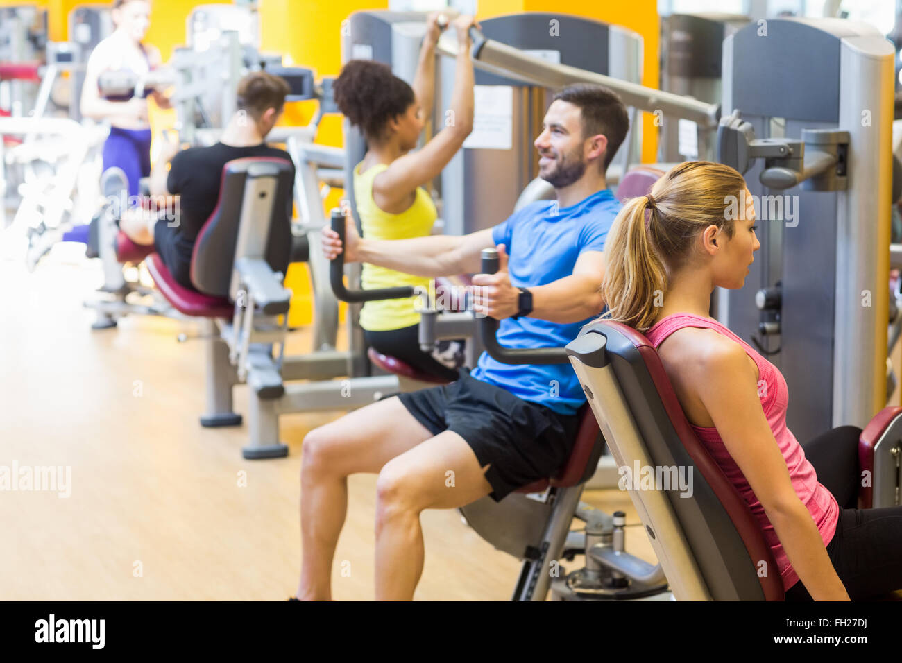 Fit people using weights machines Stock Photo - Alamy