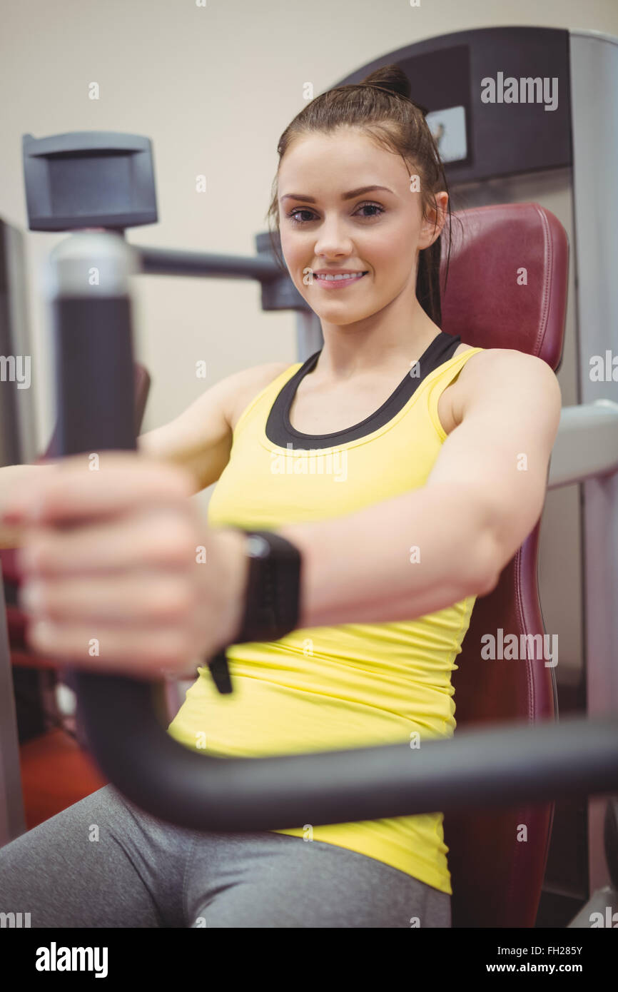 Fit woman using weights machine Stock Photo - Alamy