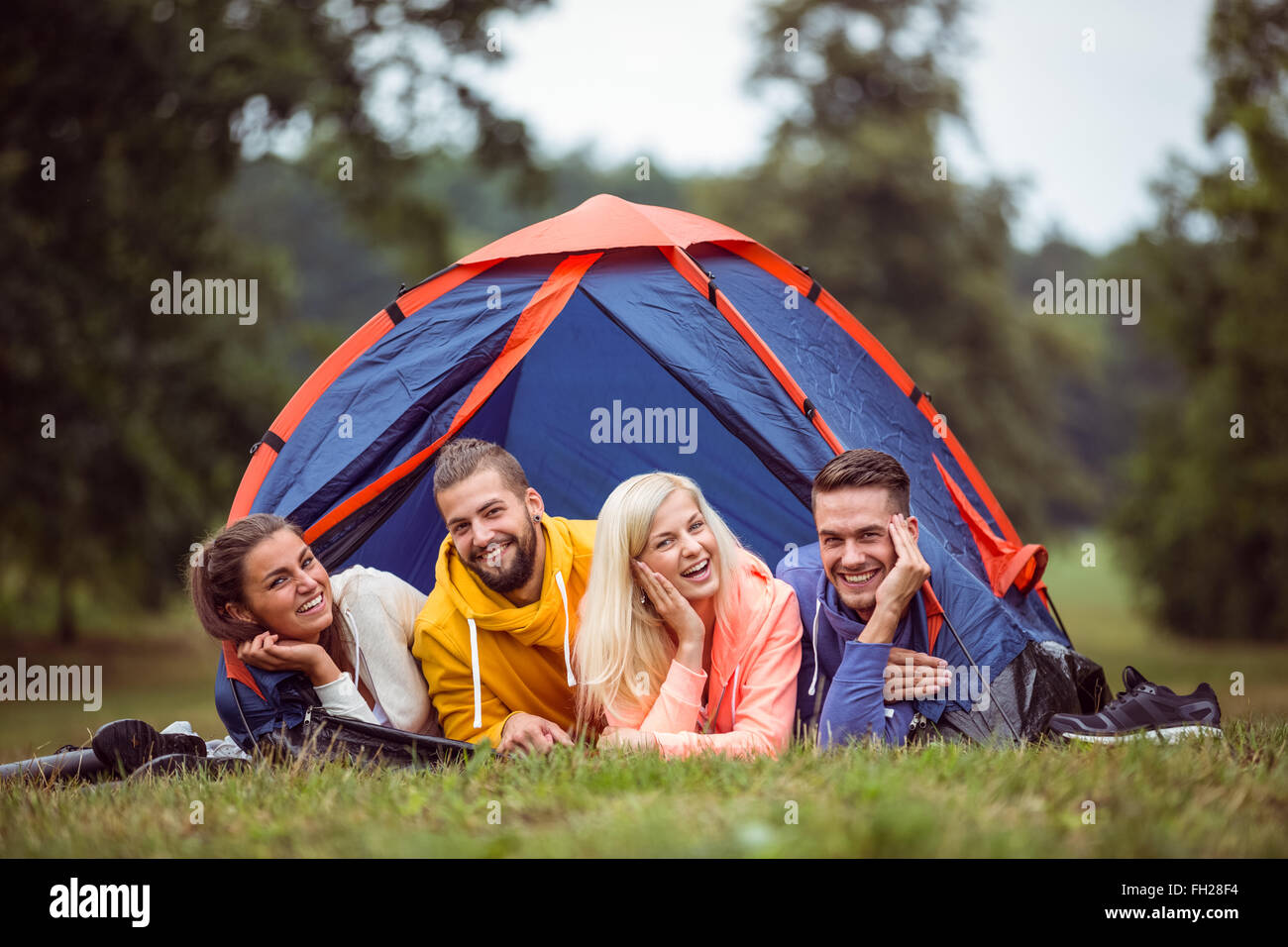 Happy friends lying in their tent Stock Photo - Alamy
