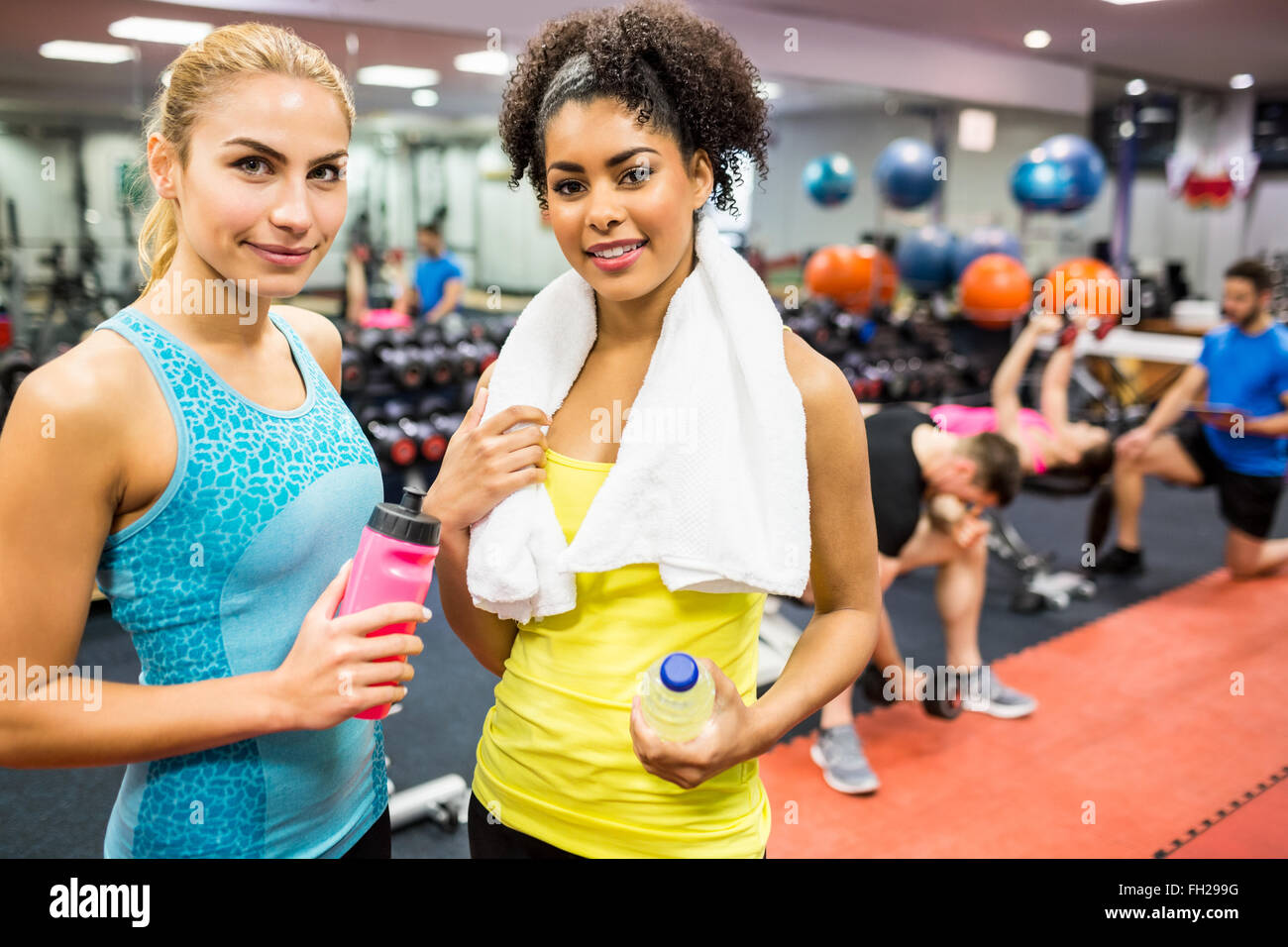 Fit women smiling at camera in weights room Stock Photo - Alamy
