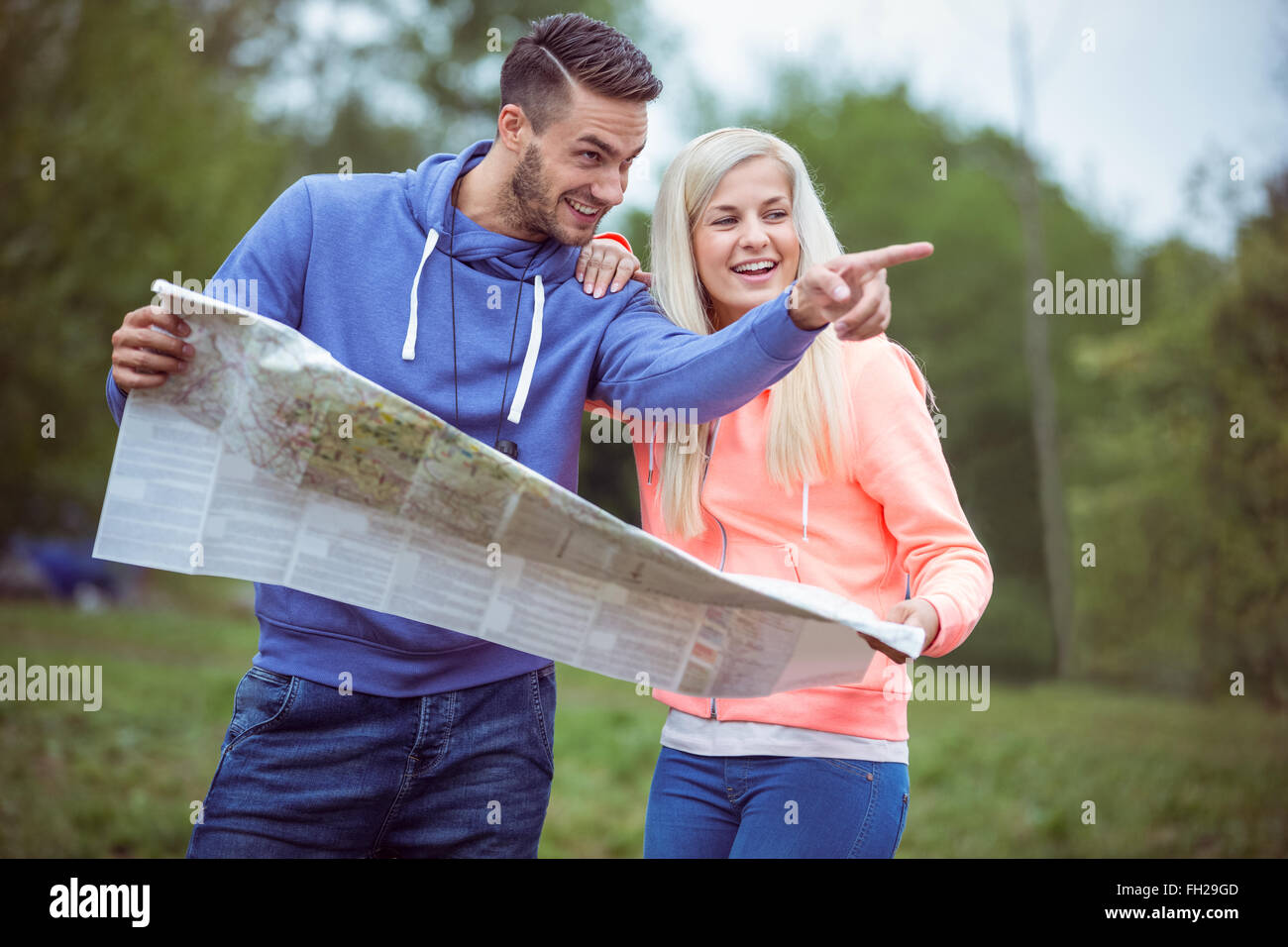 Happy couple reading a map together Stock Photo - Alamy