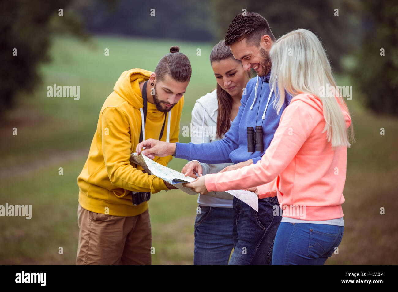 Happy friends reading a map together Stock Photo - Alamy