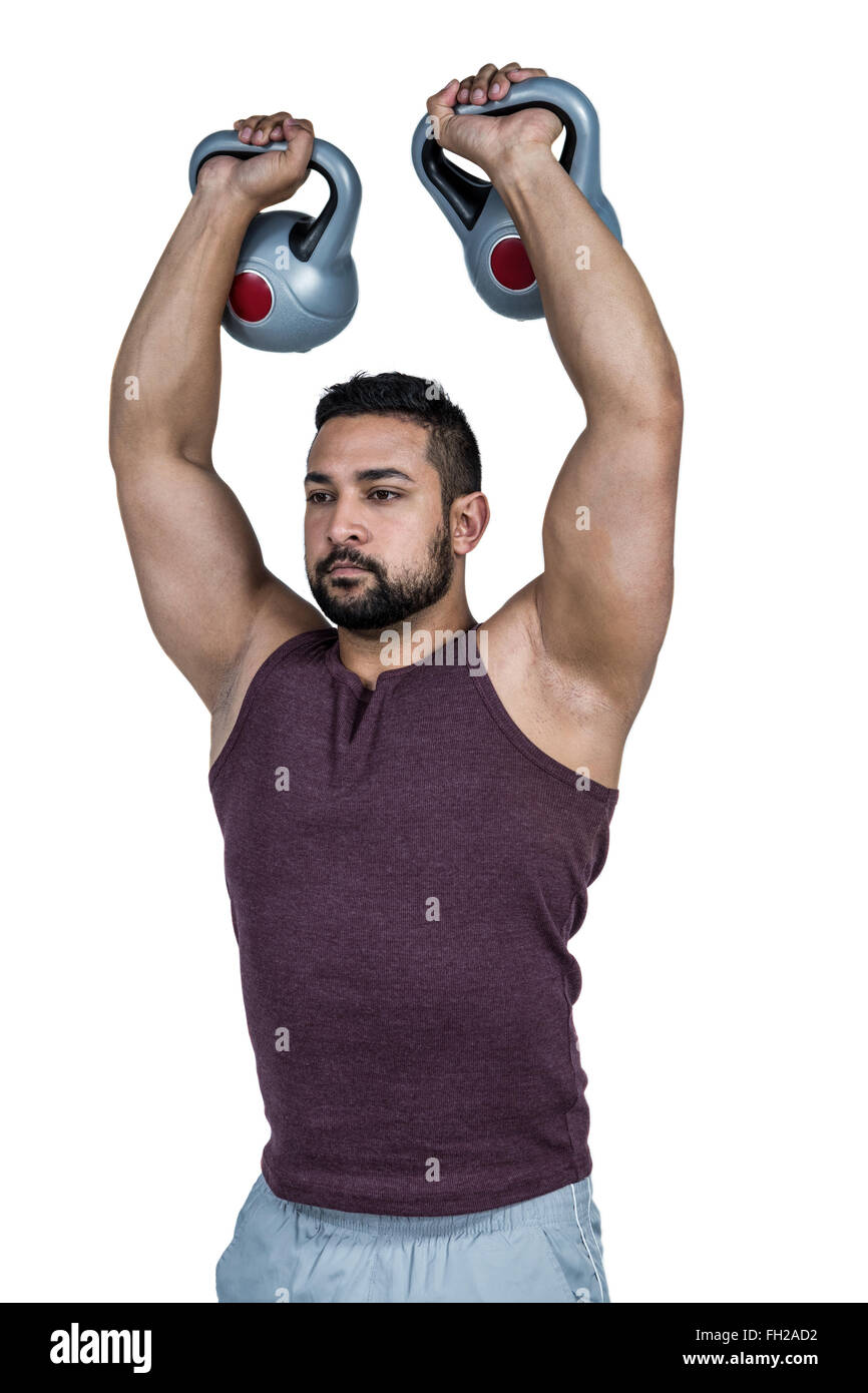 Muscular serious man lifting kettlebells Stock Photo - Alamy