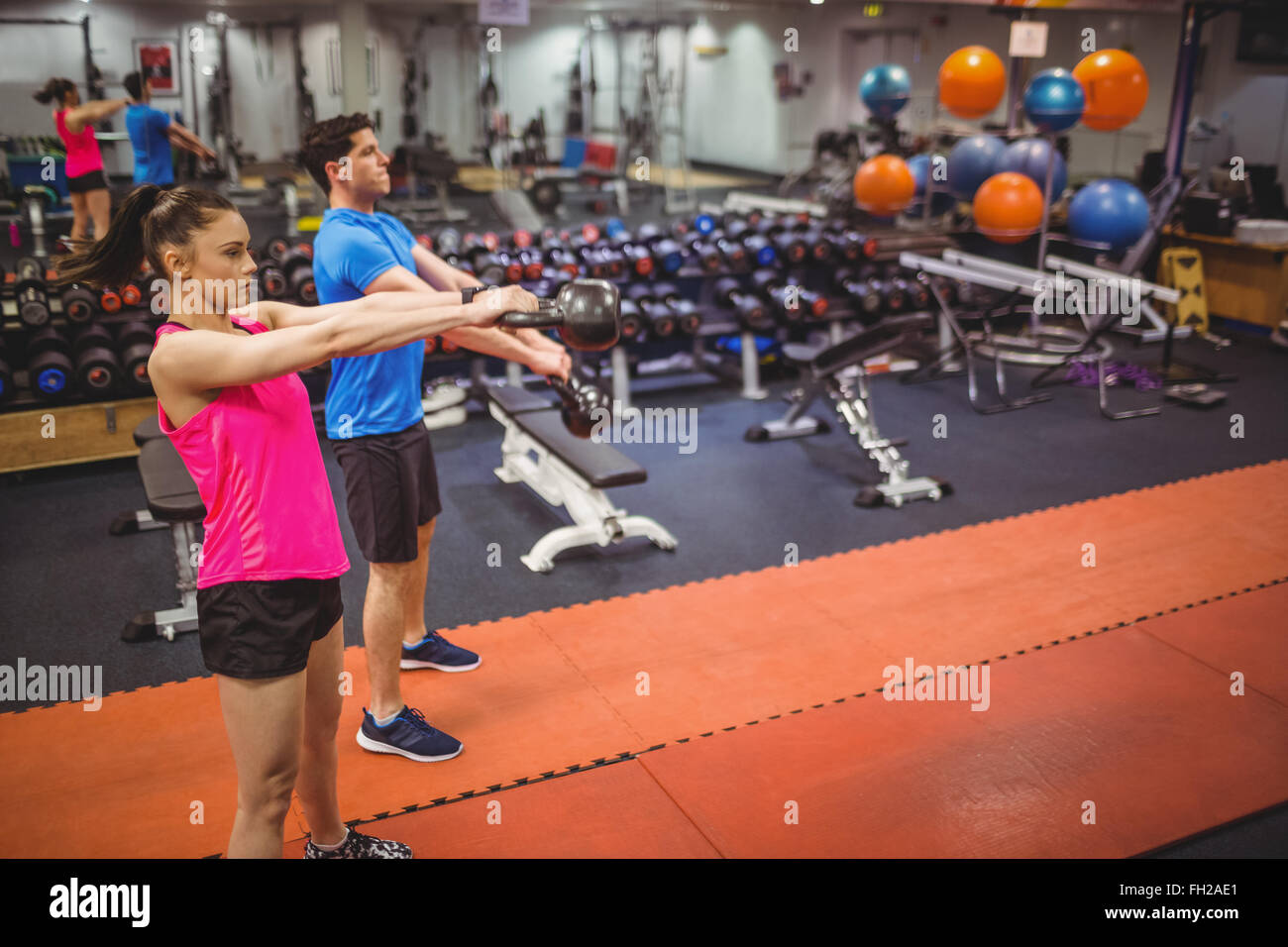 Fit couple working out in weights room Stock Photo - Alamy
