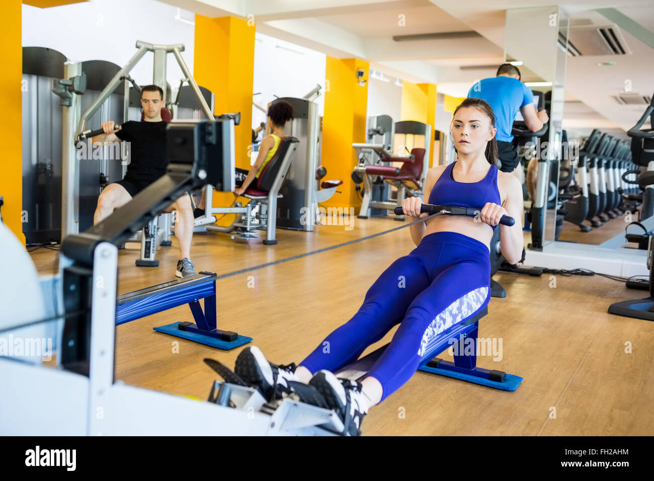 Fit woman using the rowing machine Stock Photo - Alamy