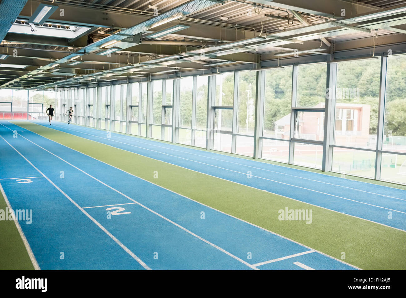 Couple running on the indoor track Stock Photo - Alamy