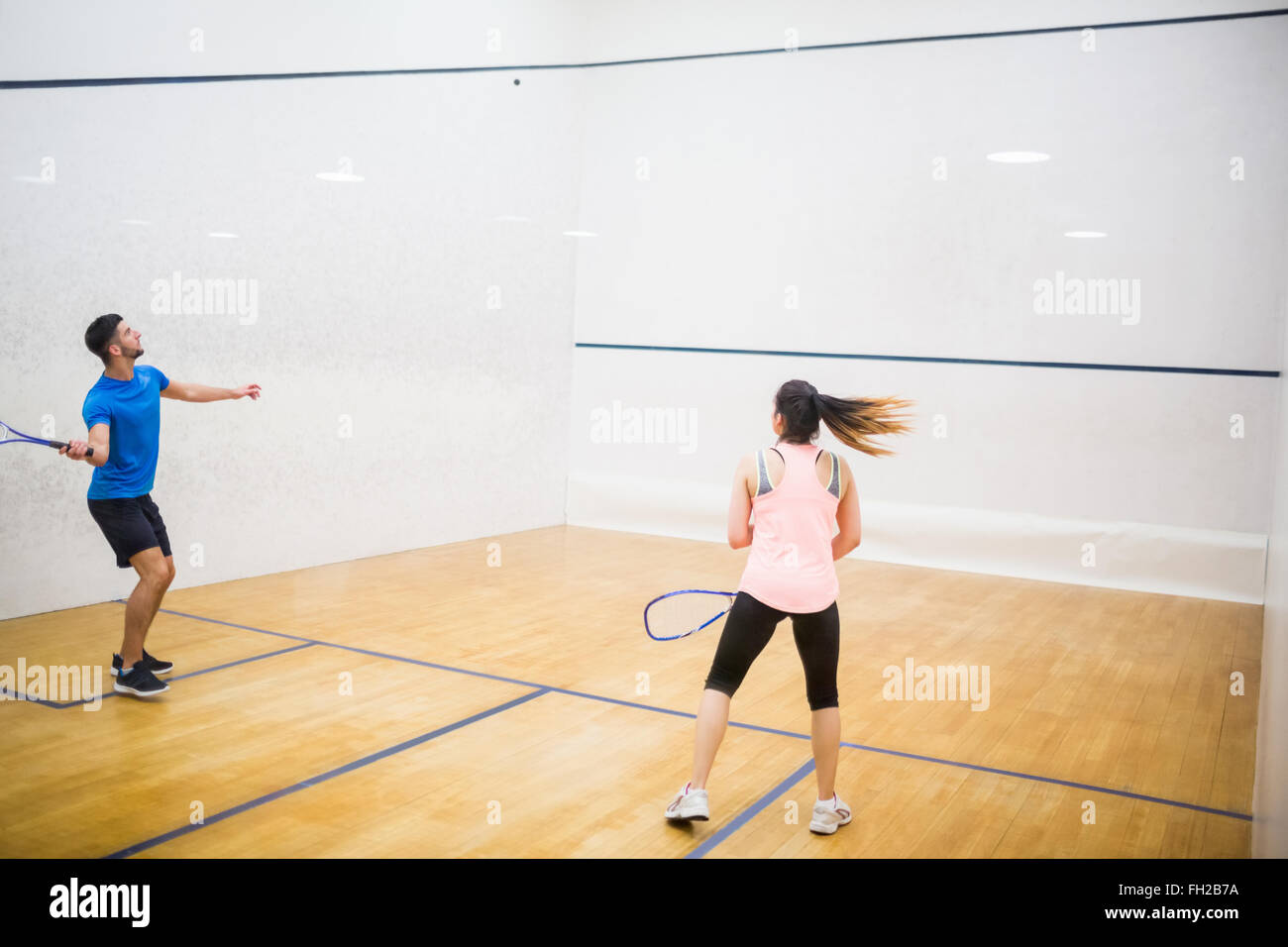 Competitive couple playing squash together Stock Photo - Alamy