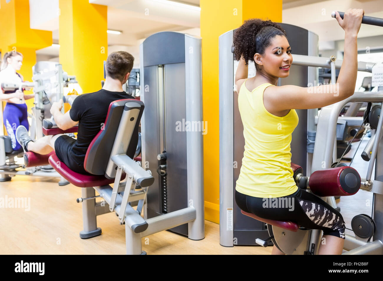 Fit people using weights machines Stock Photo - Alamy