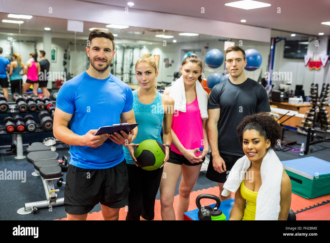 Fit people smiling at camera in weights room Stock Photo - Alamy