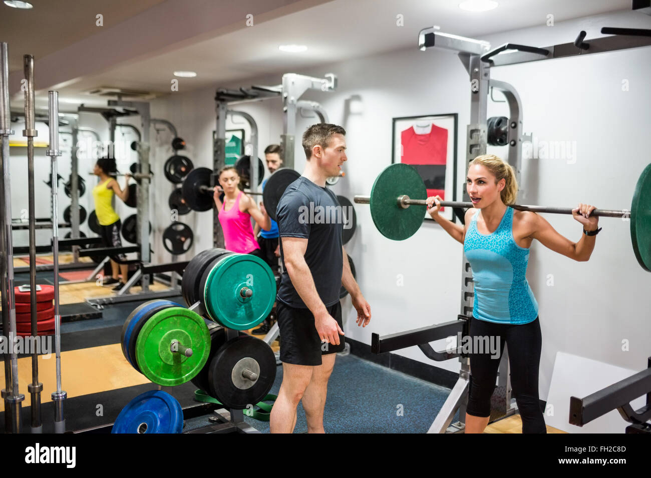 Fit woman lifting heavy barbell in weights room Stock Photo - Alamy