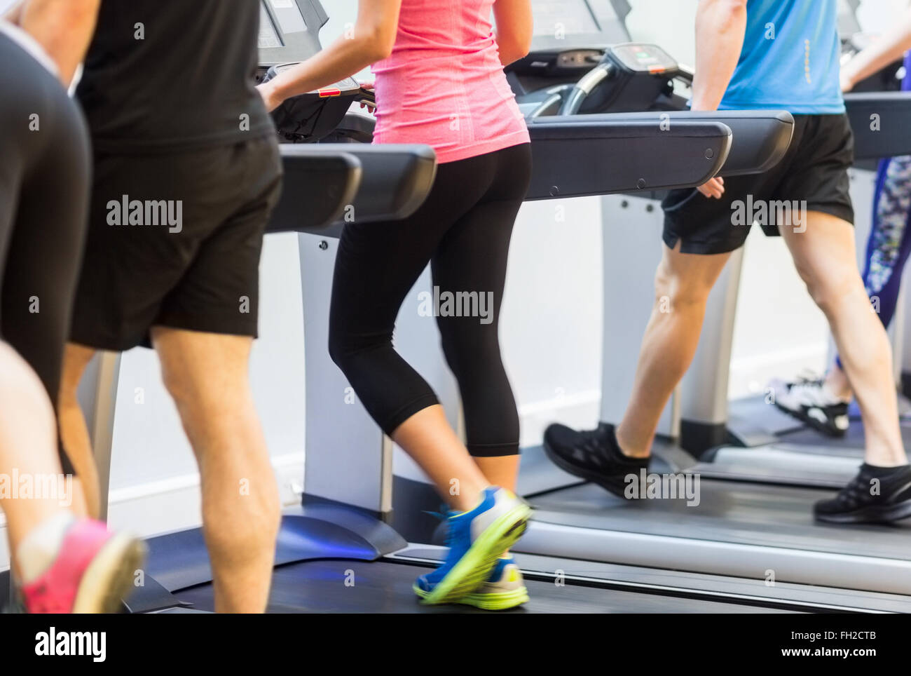 Fit people walking on treadmills Stock Photo - Alamy