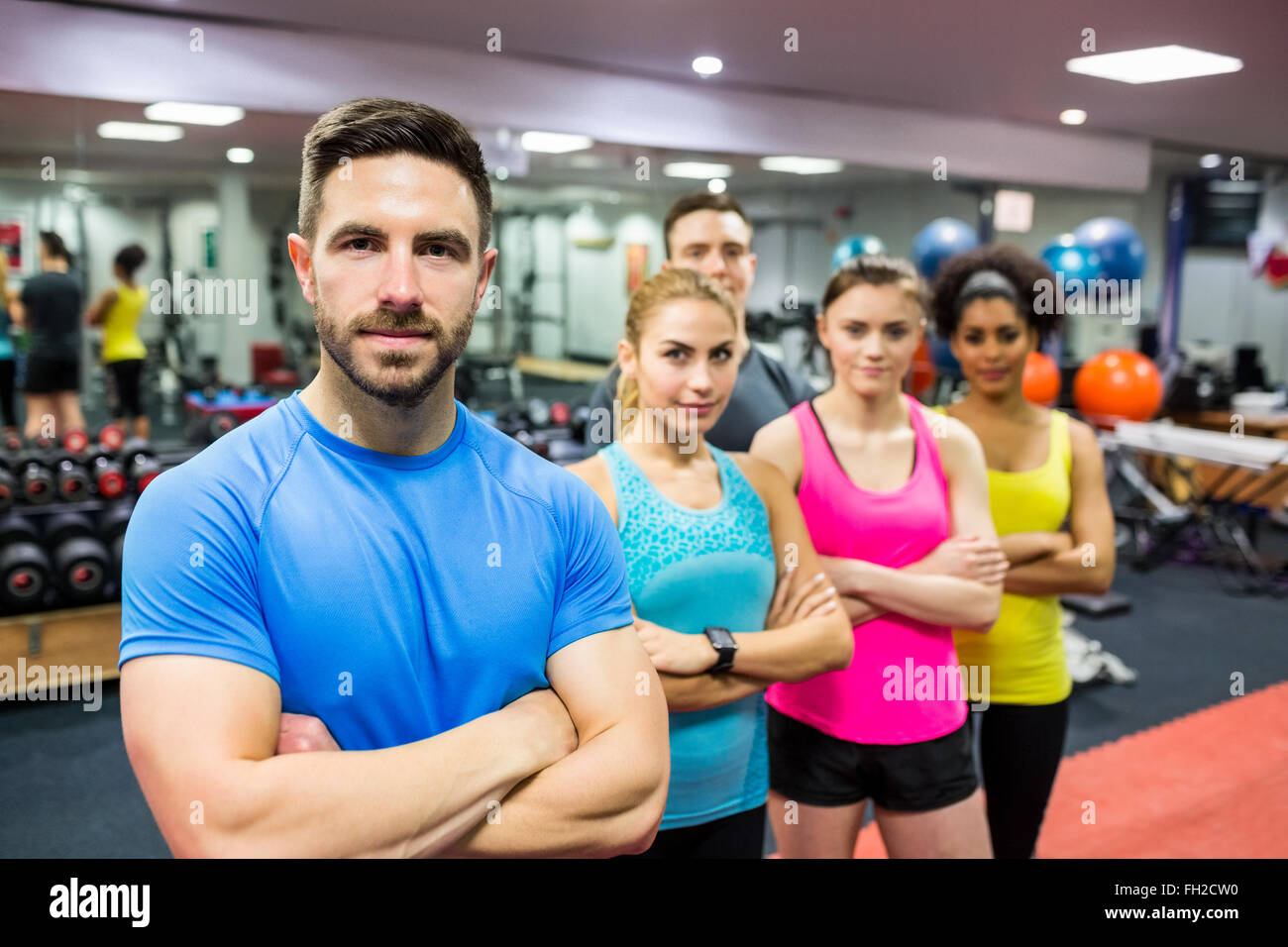 Fit people smiling at camera in weights room Stock Photo - Alamy