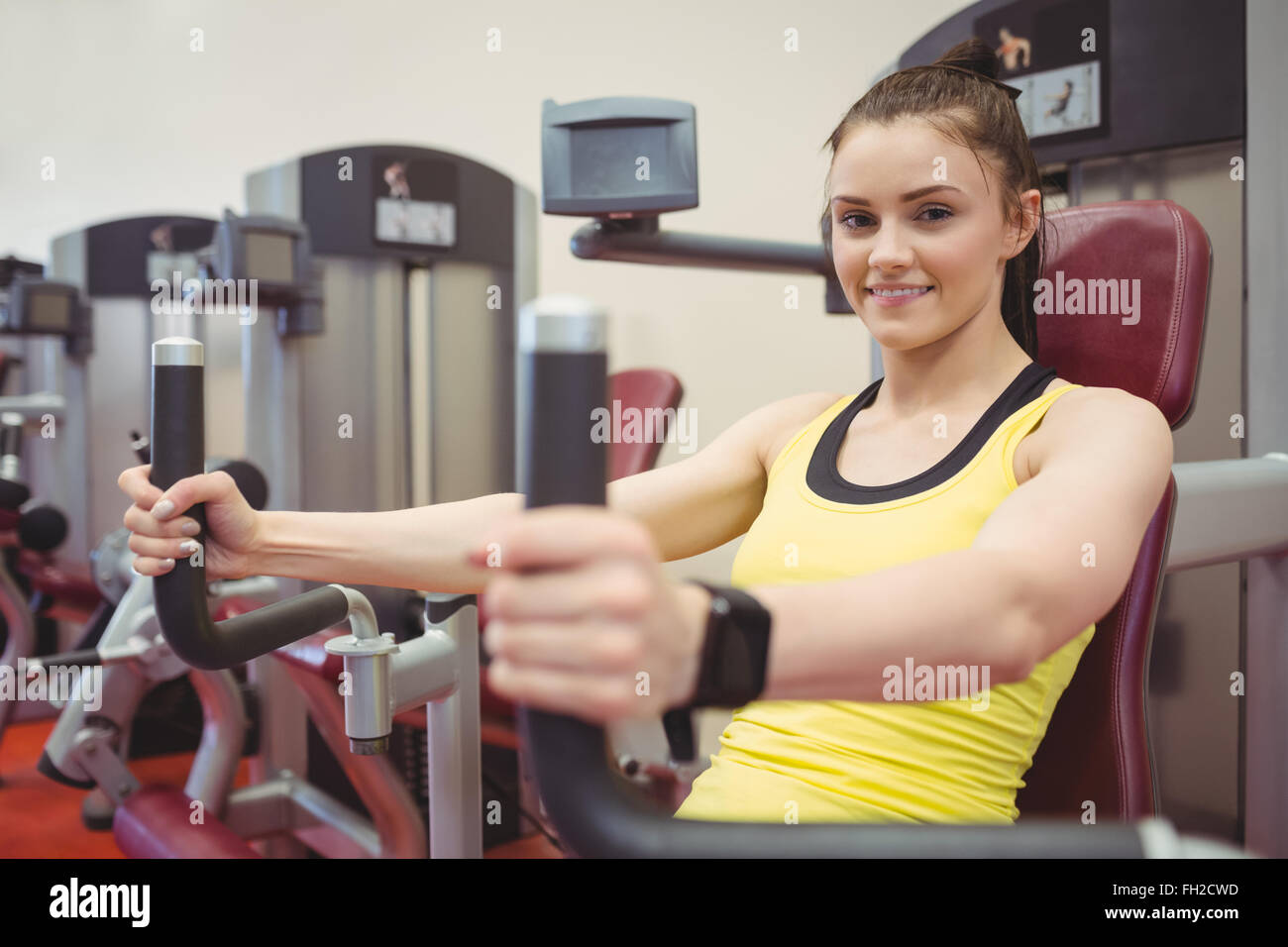 Fit woman using weights machine Stock Photo - Alamy