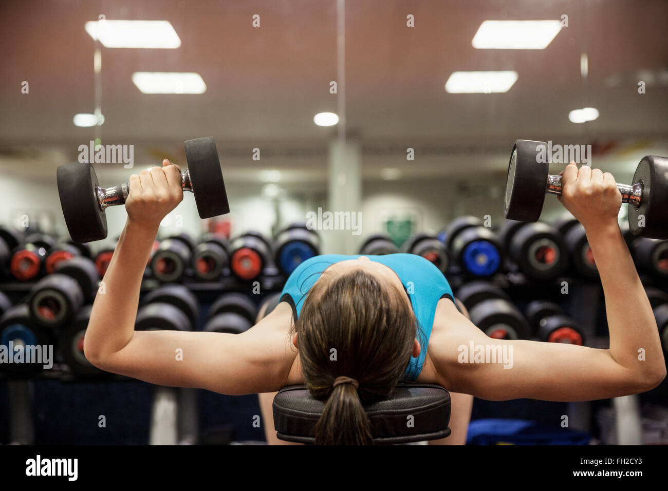 Woman lifting dumbbell weights while lying down Stock Photo - Alamy