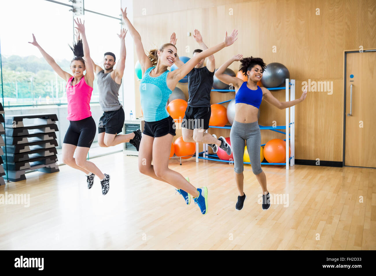 Fitness class jumping up in studio Stock Photo - Alamy