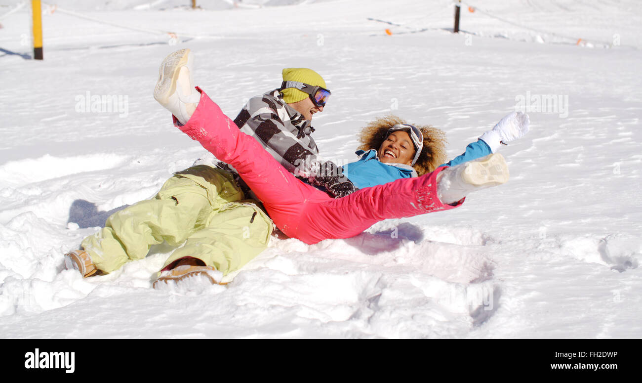 Young couple enjoying a frolic in the snow Stock Photo - Alamy